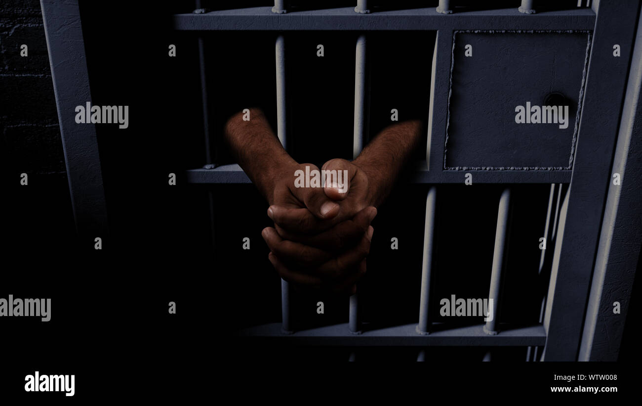 A closeup of a dimly lit prison holding cell door with a pair of ...