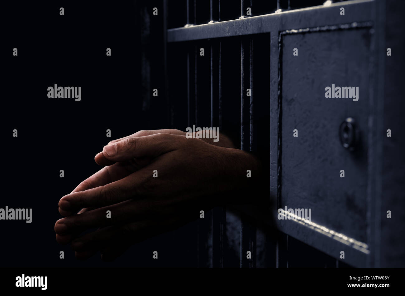 A closeup of a dimly lit prison holding cell door with a pair of ...