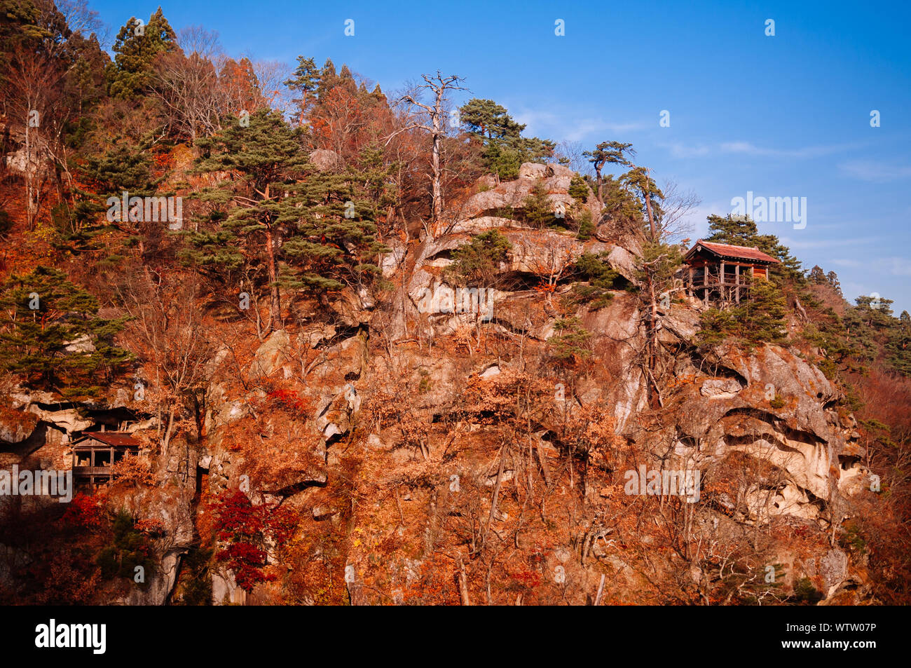 Old wooden buildings on rock cliff in evening at Yamadera Risshaku ji ...