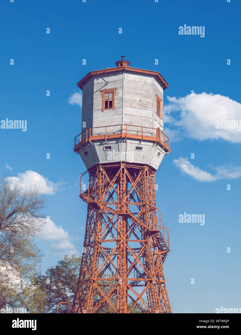 Old wooden water tower with keeper room over blue sky Stock Photo - Alamy