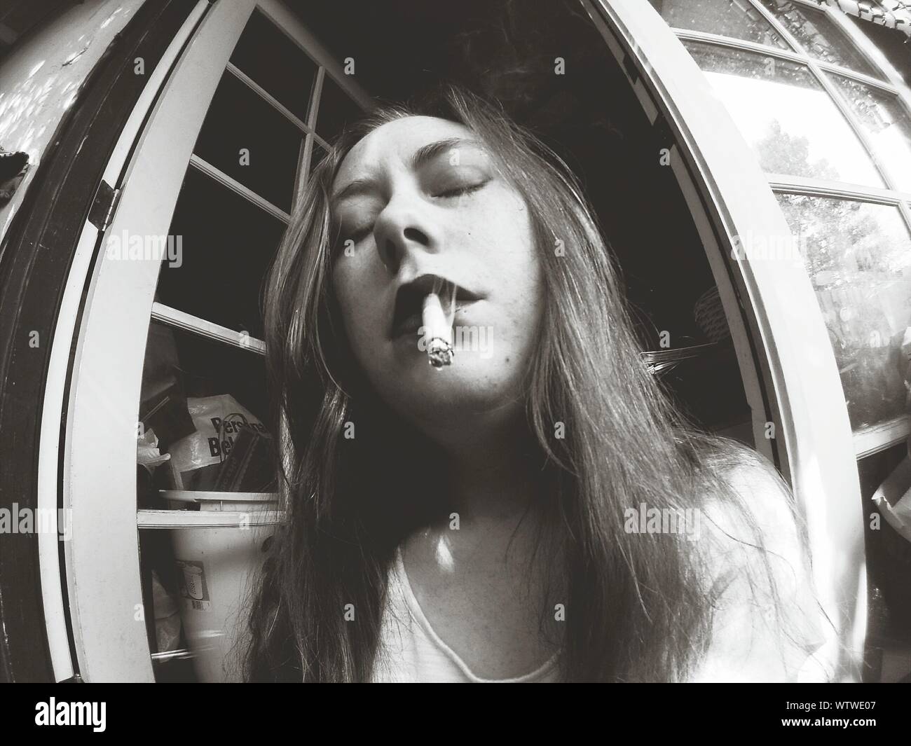 Woman smoking by window hi-res stock photography and images - Alamy