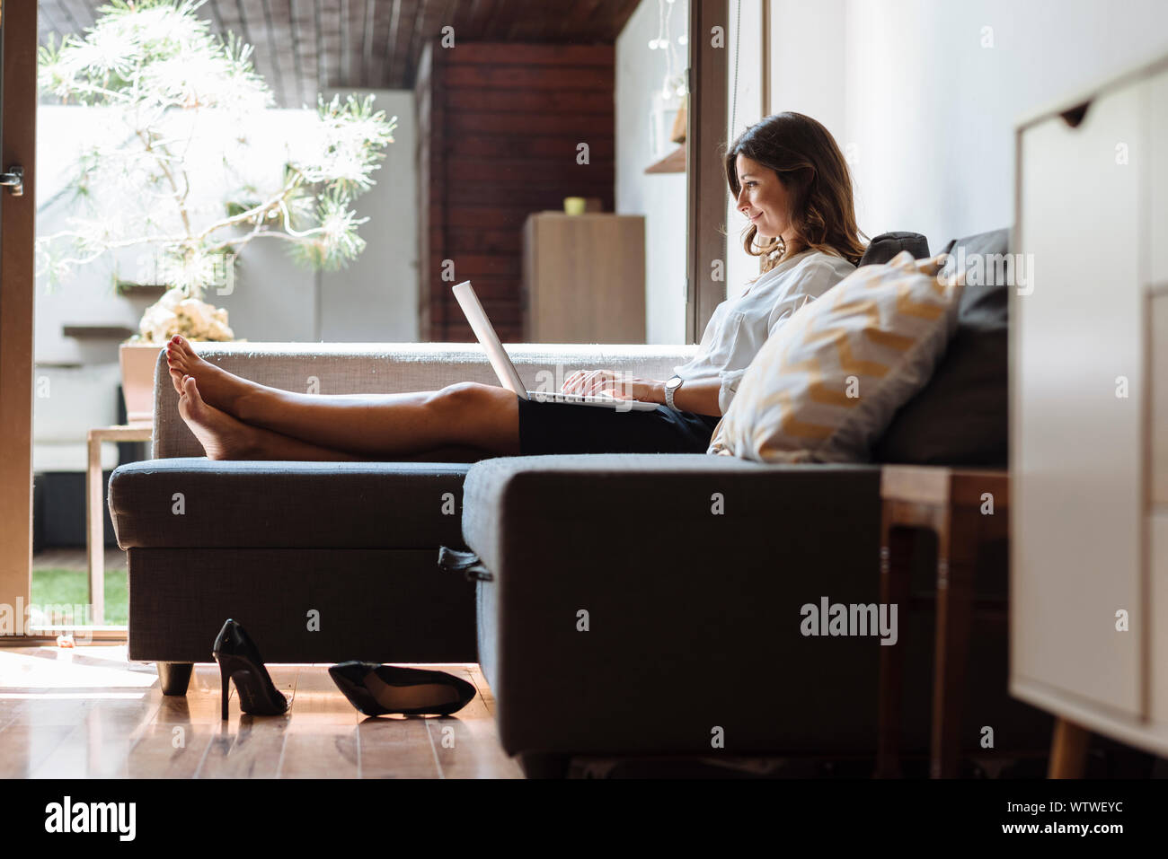 Brunette woman lying on couch hi-res stock photography and images - Alamy