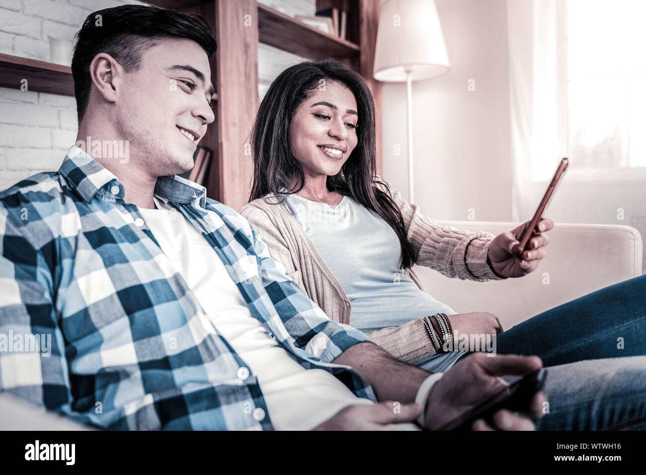 Contented lady showing her phone with funny content to boyfriend Stock ...
