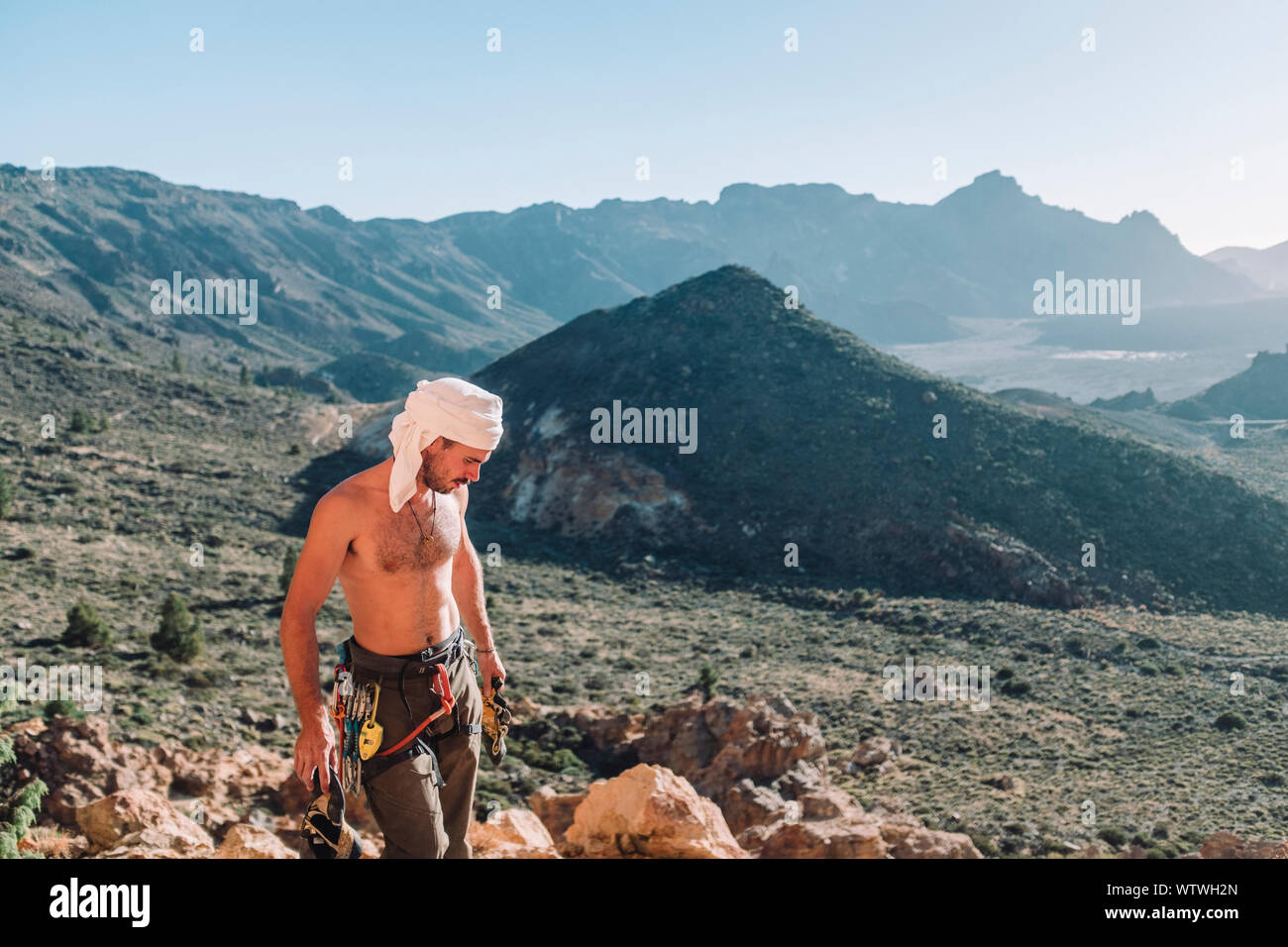 Upper body of shirtless male climber standing in mountain Stock Photo ...