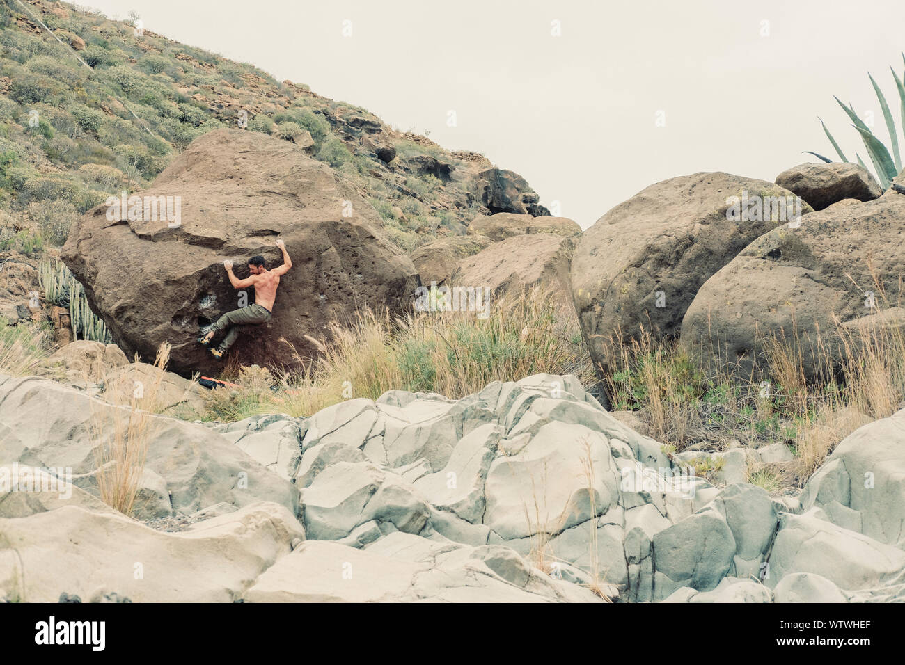 Pulled back of a man climbing a boulder route Stock Photo - Alamy