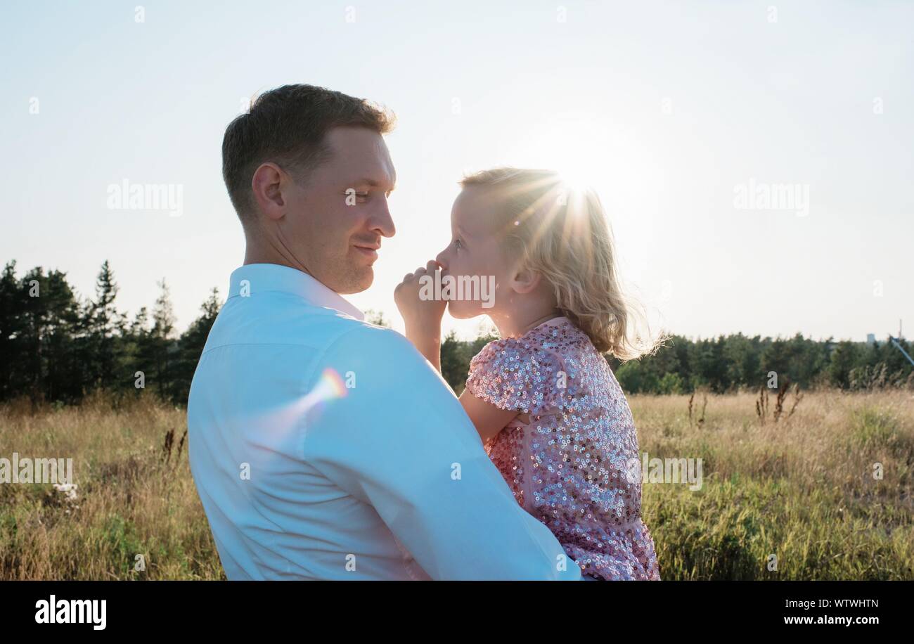 portrait of a young girl & her father looking at each other lovingly ...