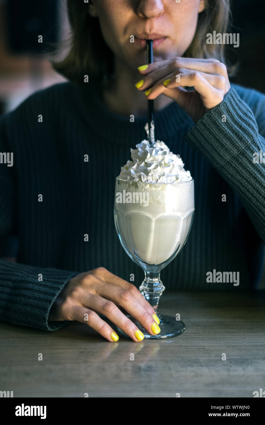 Young Woman Drinking Milkshake in cafe Stock Photo - Alamy