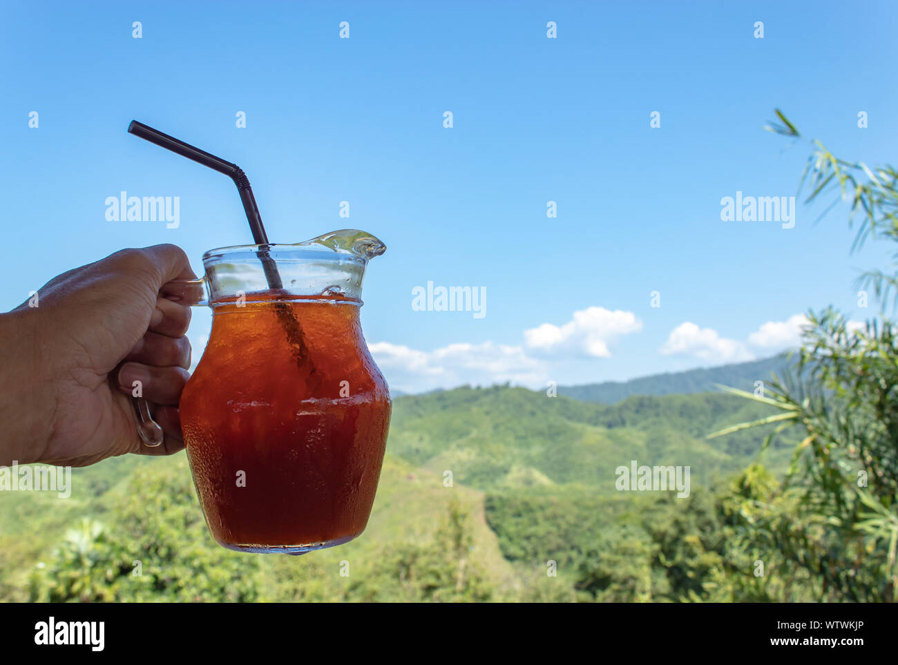 Hand holding Iced black coffee in a glass jar and view mountain Stock ...