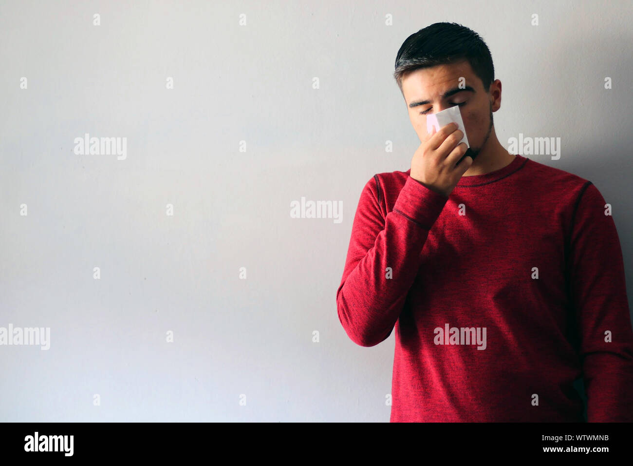 Medicine and health concept: Young man coughing and covering mouth with ...