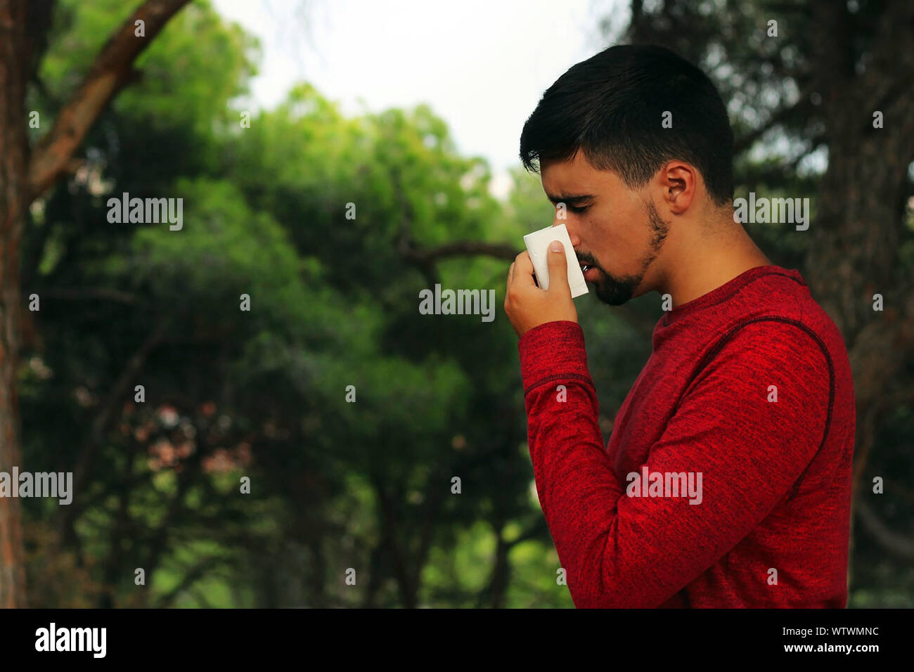 Medicine and health concept: Young man coughing and covering mouth with ...