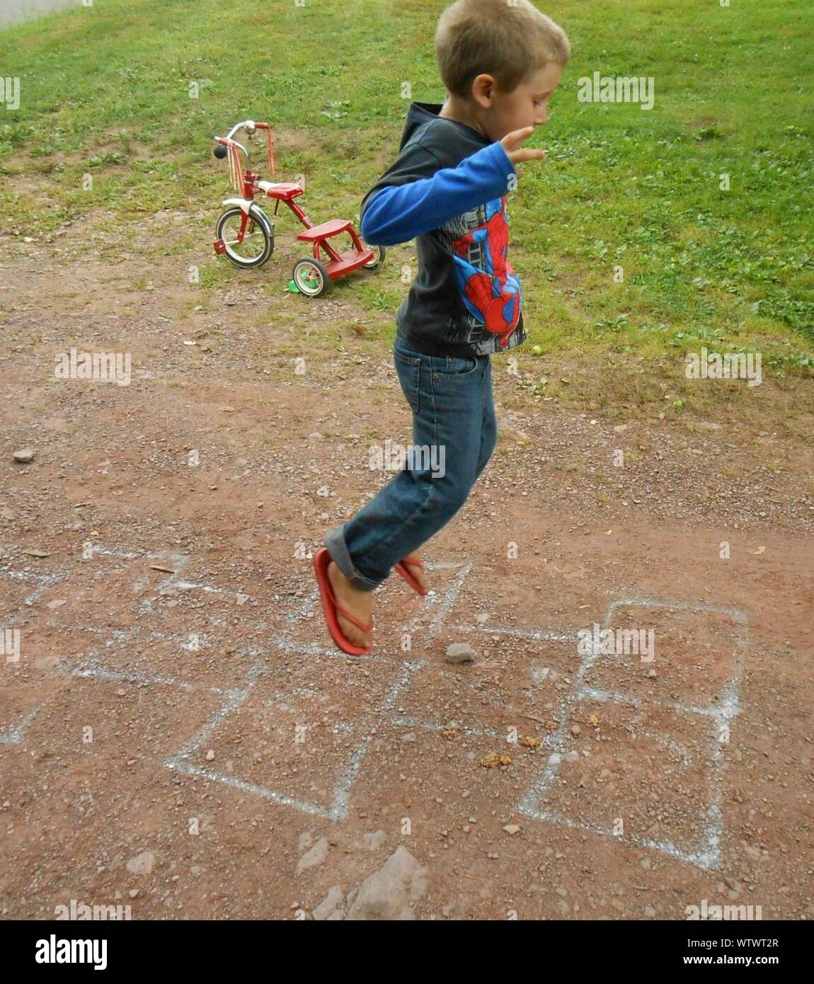 Side View Of Boy Playing Hopscotch On Field Stock Photo - Alamy