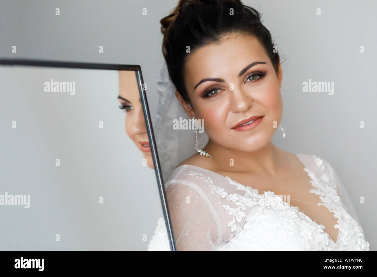 Bride morning. The bride is standing near the mirror, waiting for the ...