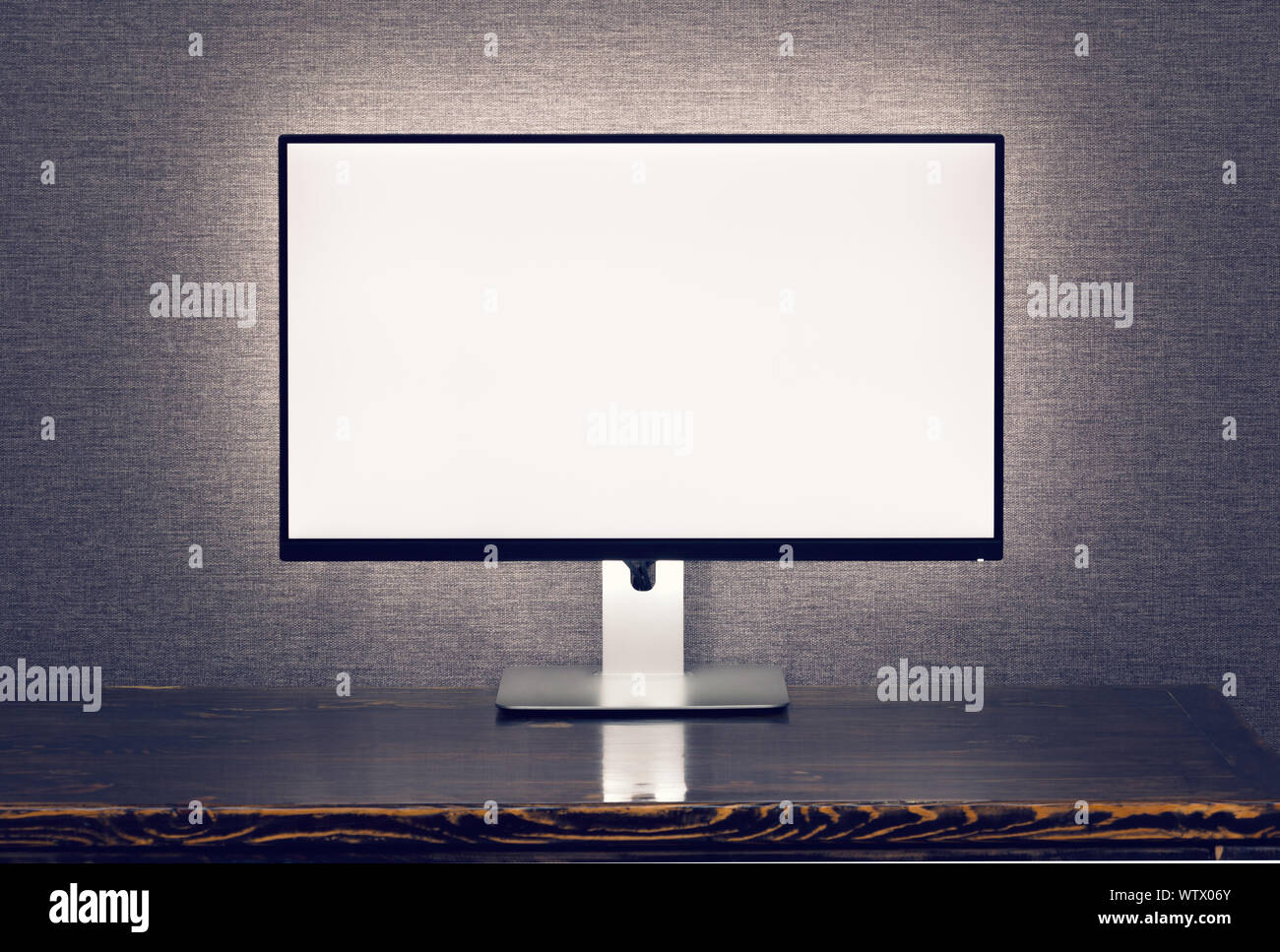 Blank monitor with backlight over gray wall in dark room Stock Photo ...