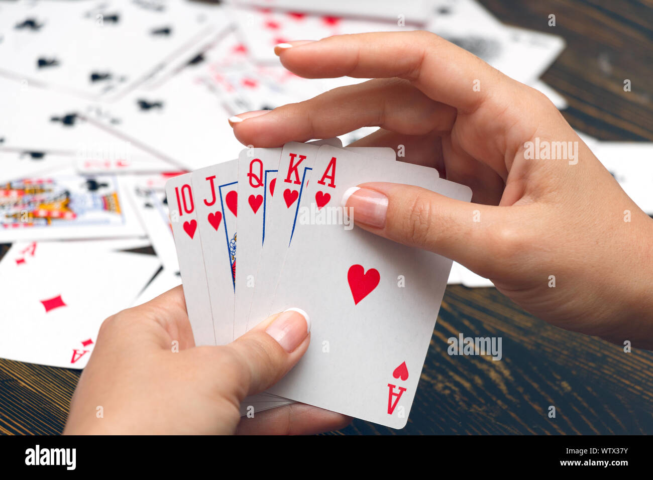 Well-conditioned female hands holding playing cards with poker ...