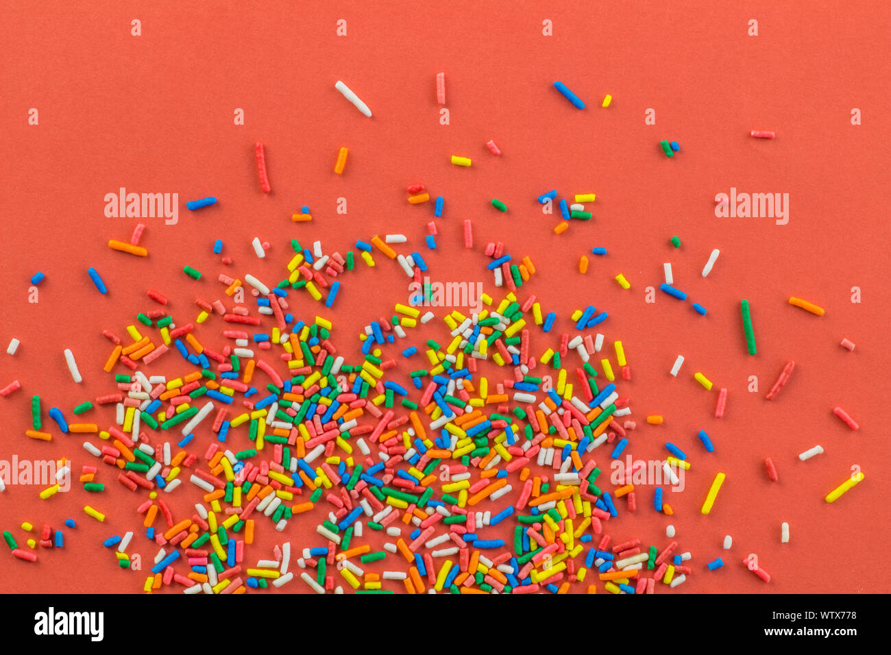 Multi-colored sprinkles on brick orange background - cake topping ...