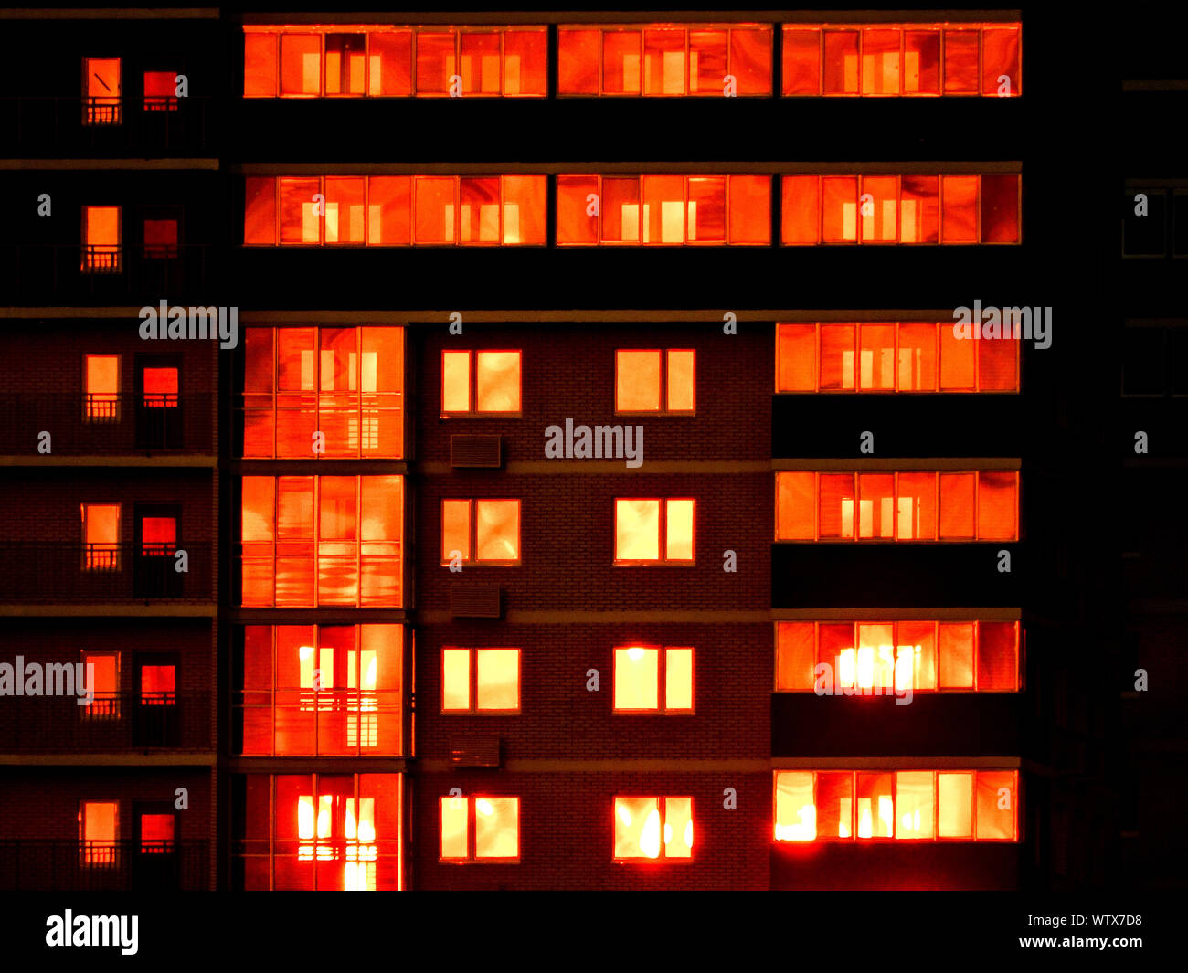 Night snapshot. Dark residential high-rise buildings, in which red ...