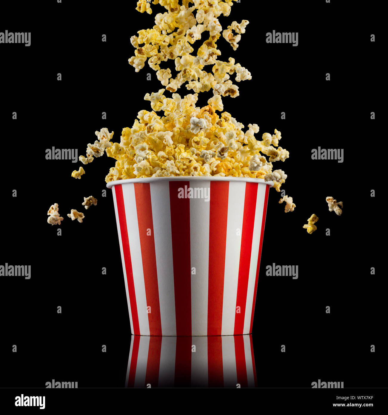 Flying popcorn from striped bucket isolated on black background Stock ...