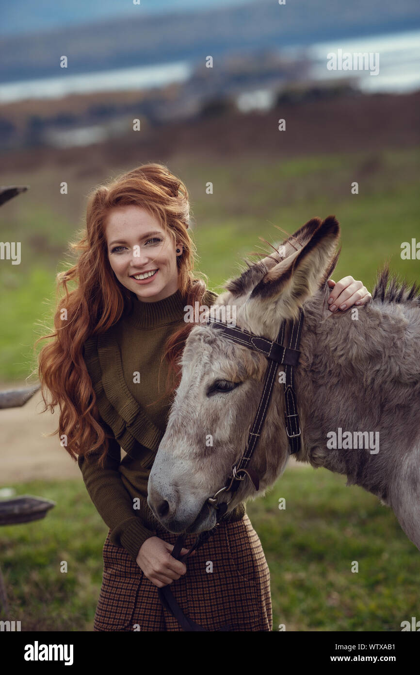 A girl with curly red hair in fashionable clothes in the style of ...