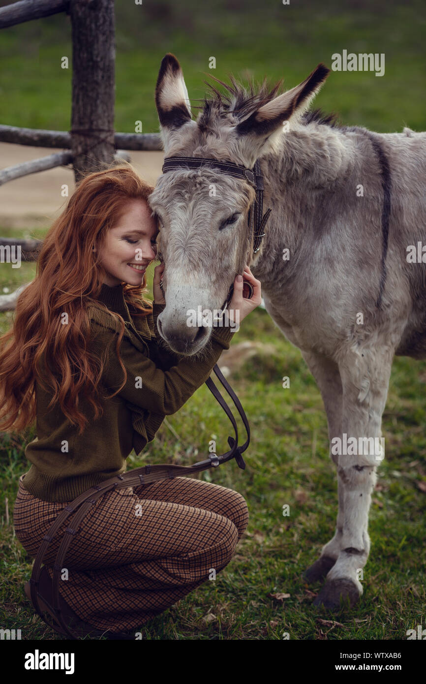 A girl with curly red hair in fashionable clothes in the style of ...
