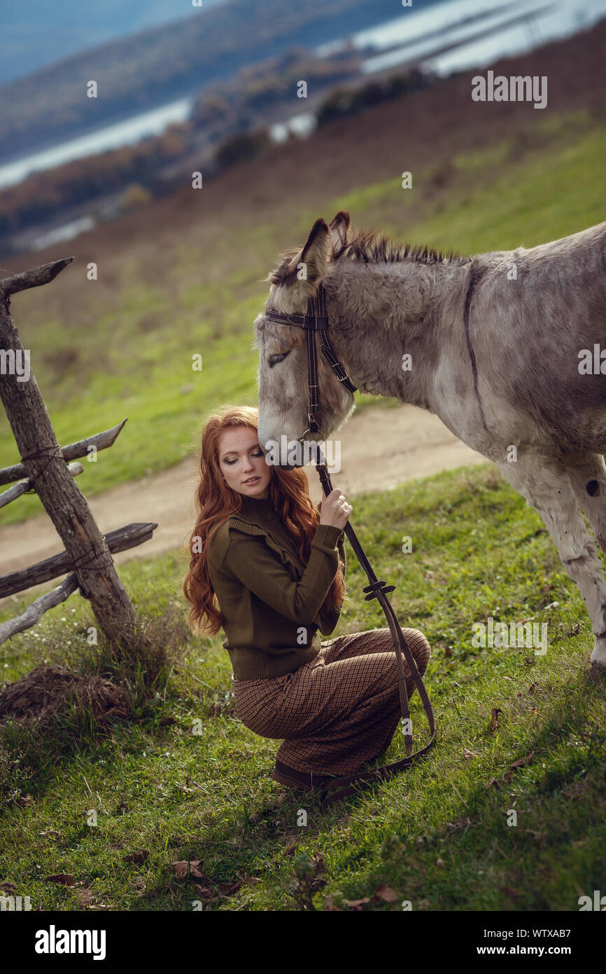 A girl with curly red hair in fashionable clothes in the style of ...