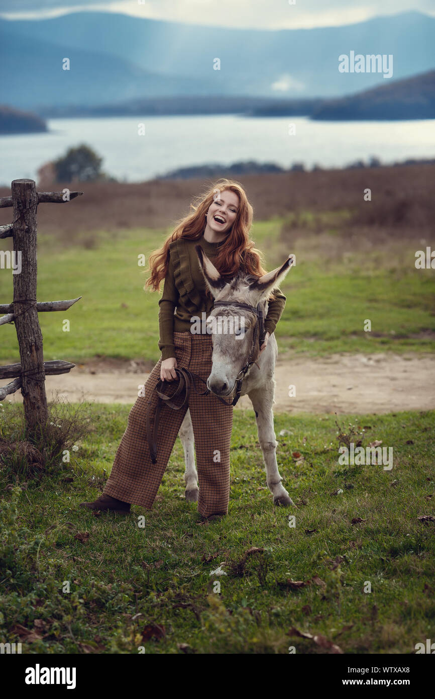 A girl with curly red hair in fashionable clothes in the style of ...