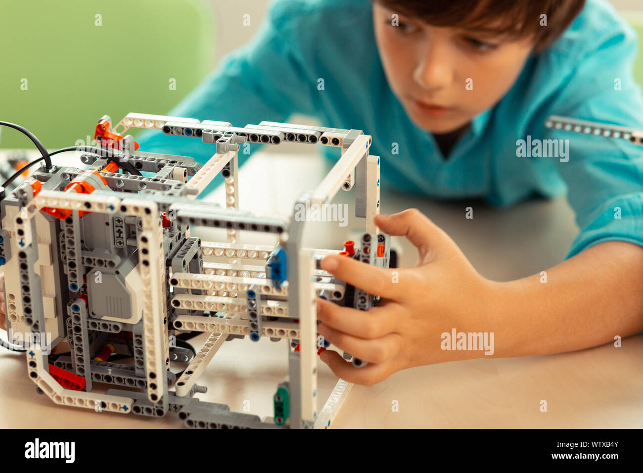 Serious schoolboy working on his complicated robot Stock Photo - Alamy