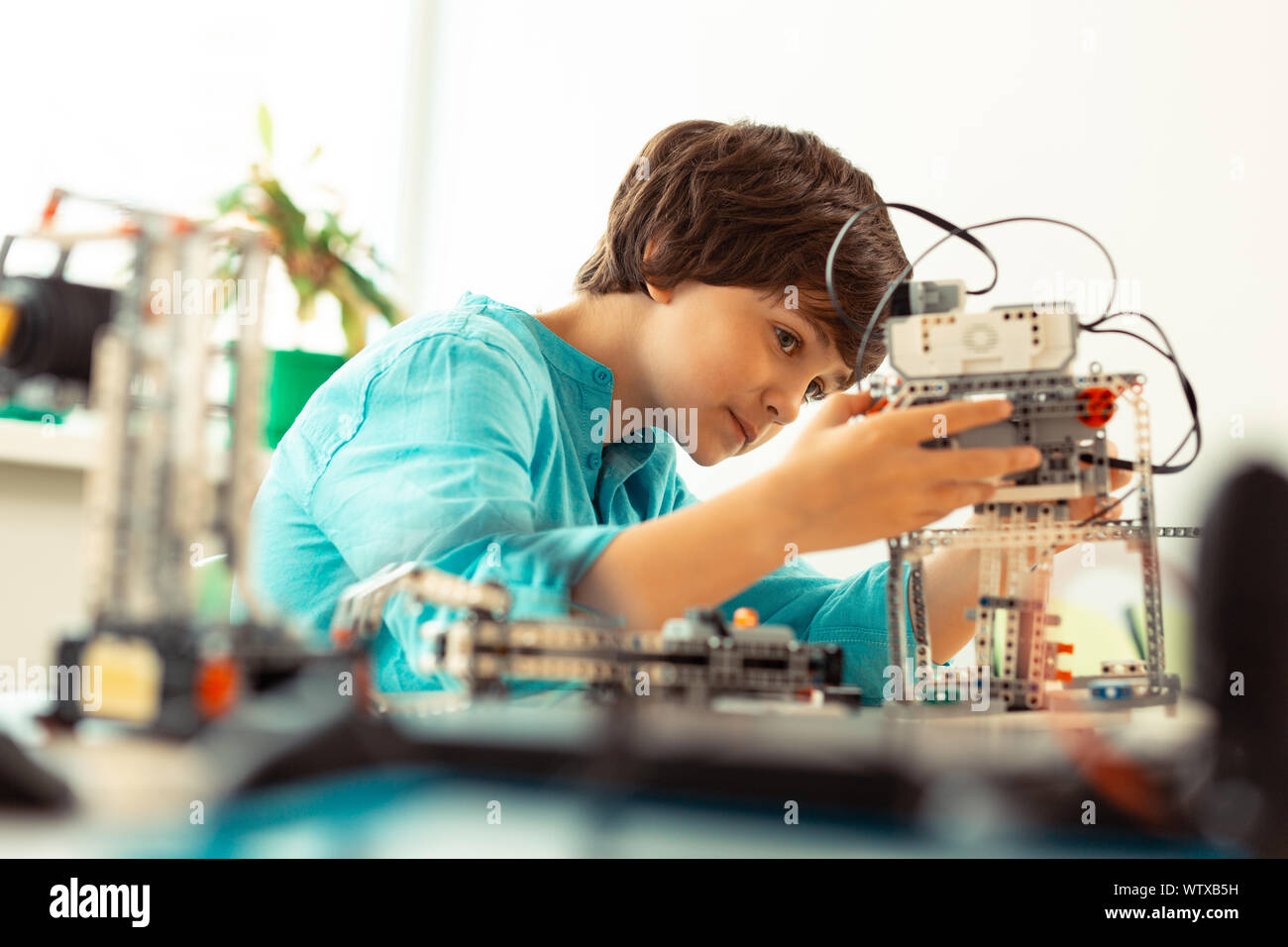Enthusiastic pupil fixing the robot at science lesson Stock Photo - Alamy