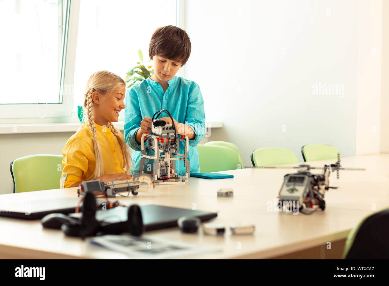 Boy showing his classmate way of building a robot Stock Photo - Alamy
