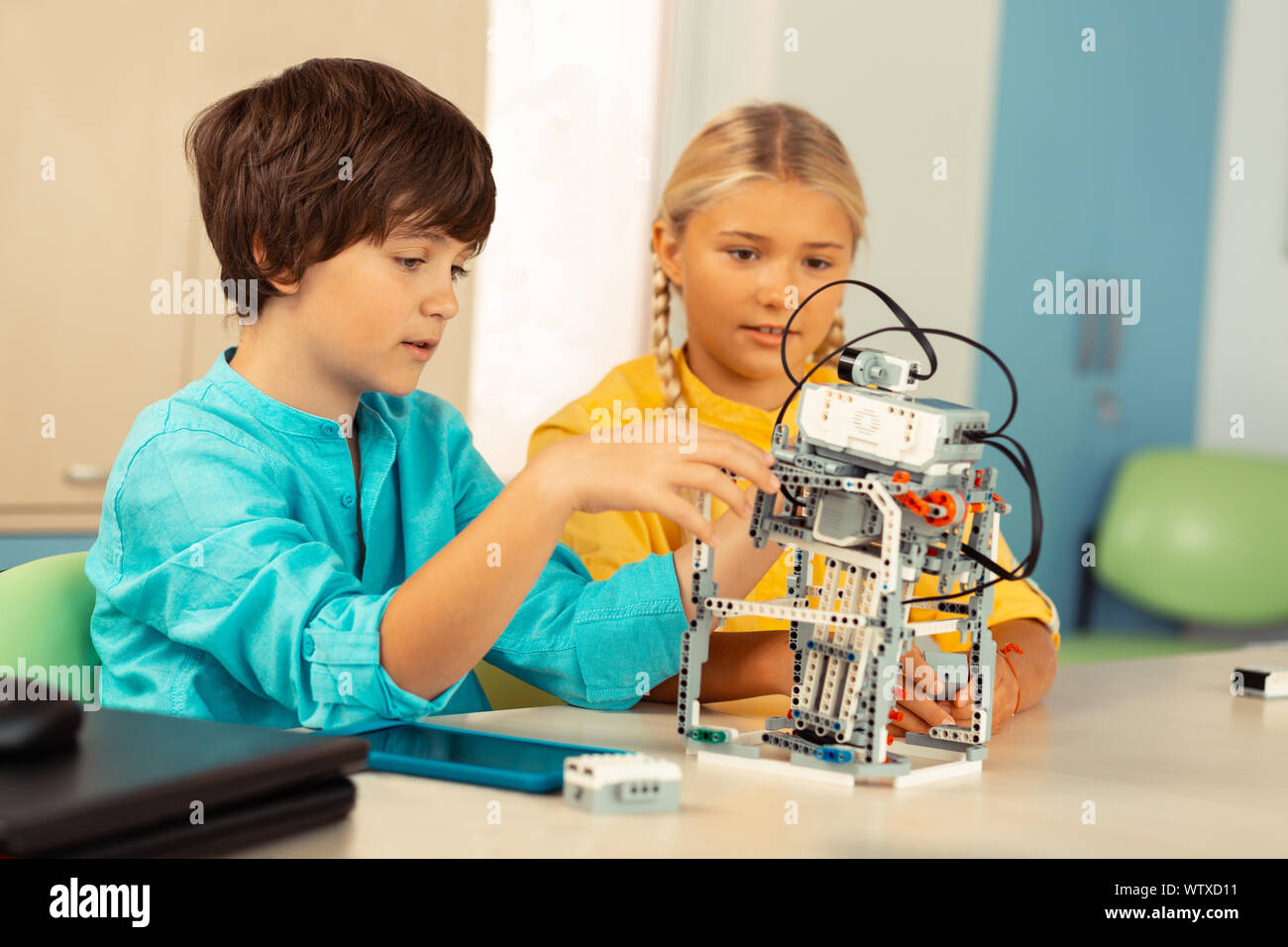 Boy explaining his classmate principals of working of his project Stock ...
