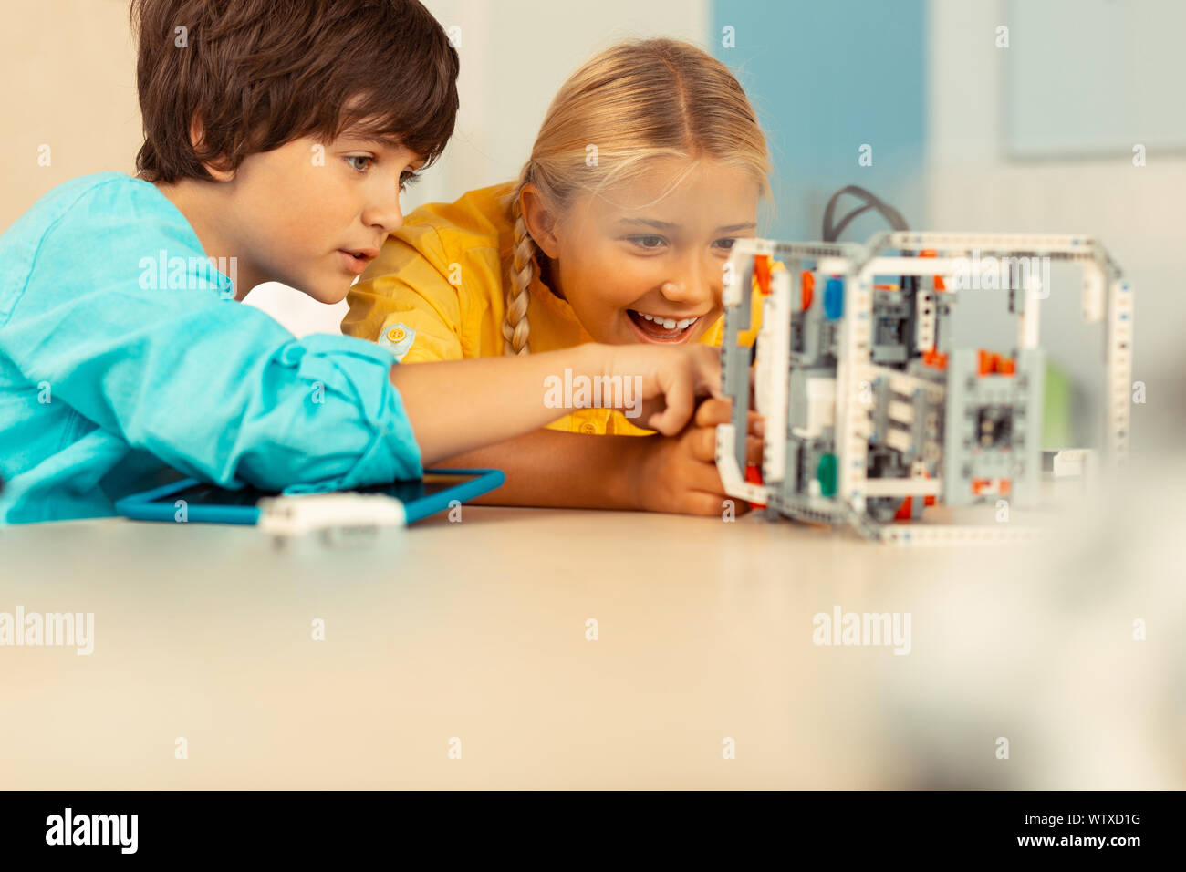 Excited children playing with the robot at science class Stock Photo ...