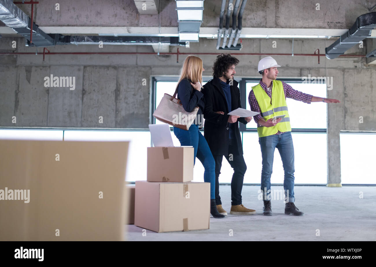 architect using tablet computer while showing house design plans to a ...