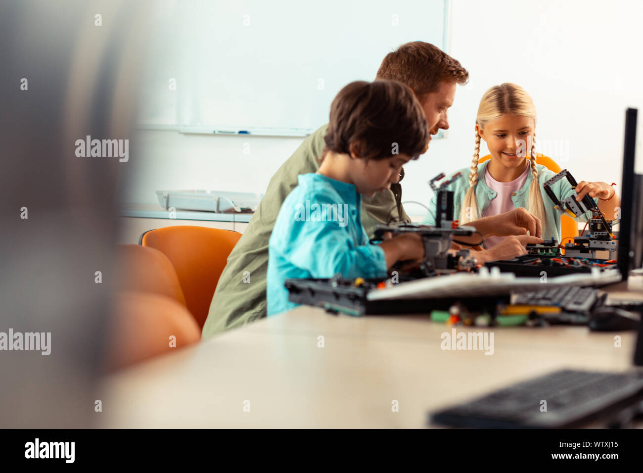 Girl and boy building robots at their science lesson Stock Photo - Alamy