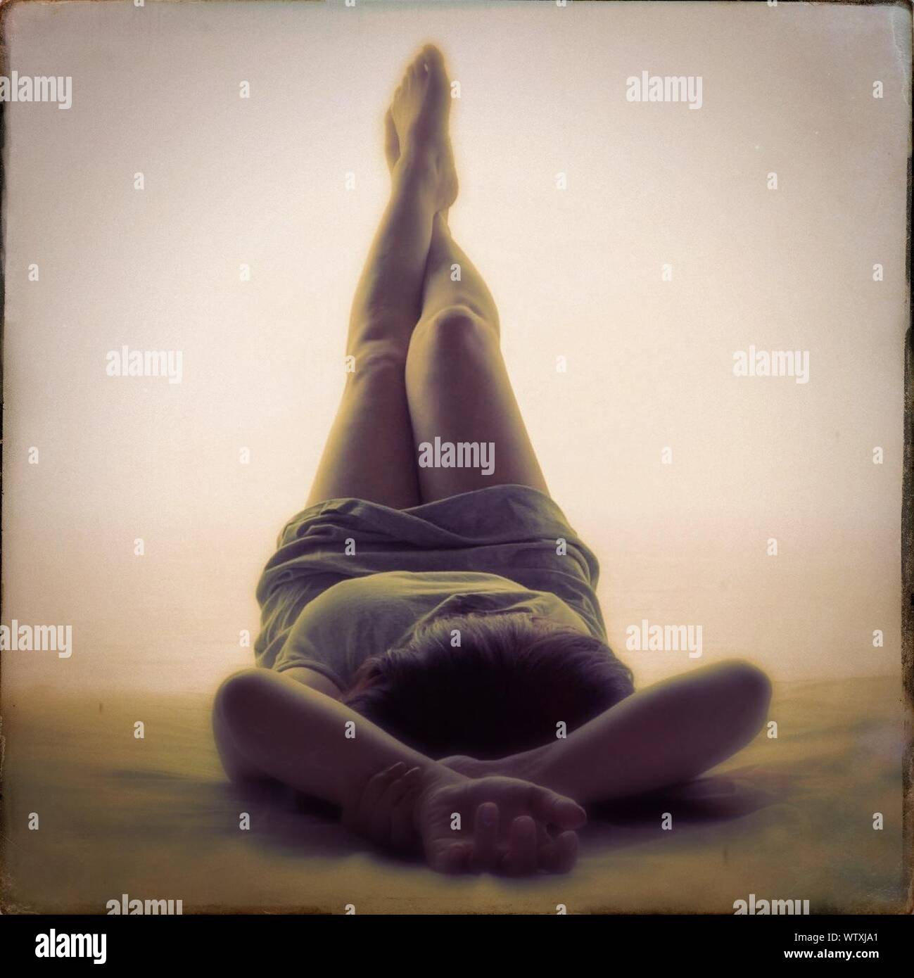 Woman lying on back legs up hi-res stock photography and images - Alamy