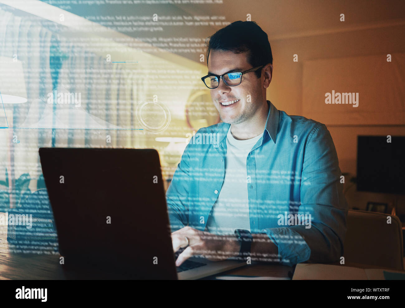 Smiling man enjoying surfing on laptop during late night Stock Photo ...