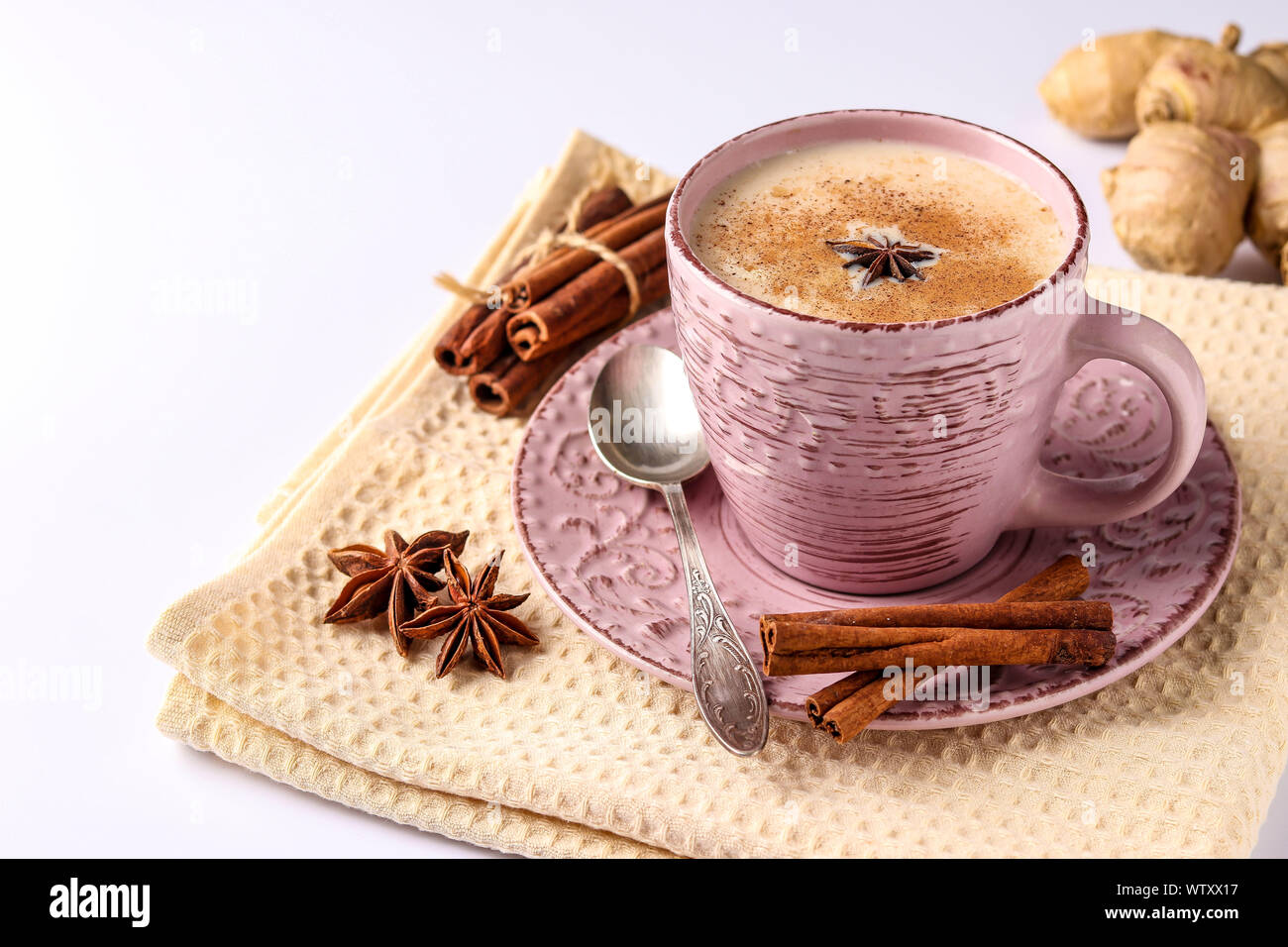 Traditional indian drink - masala tea with spices in pink cup on a ...