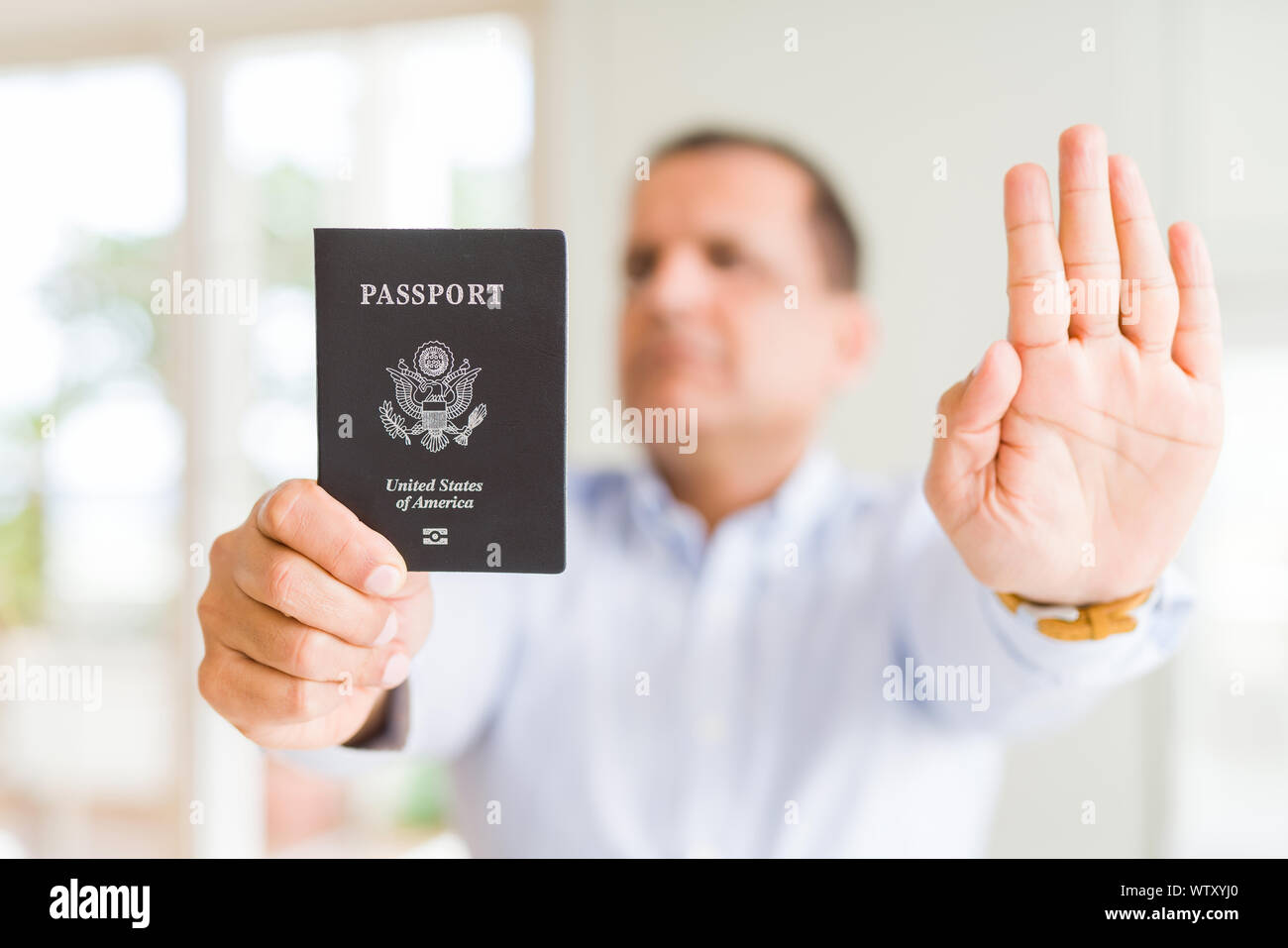 Middle age man holding holding passport of United States with open hand ...