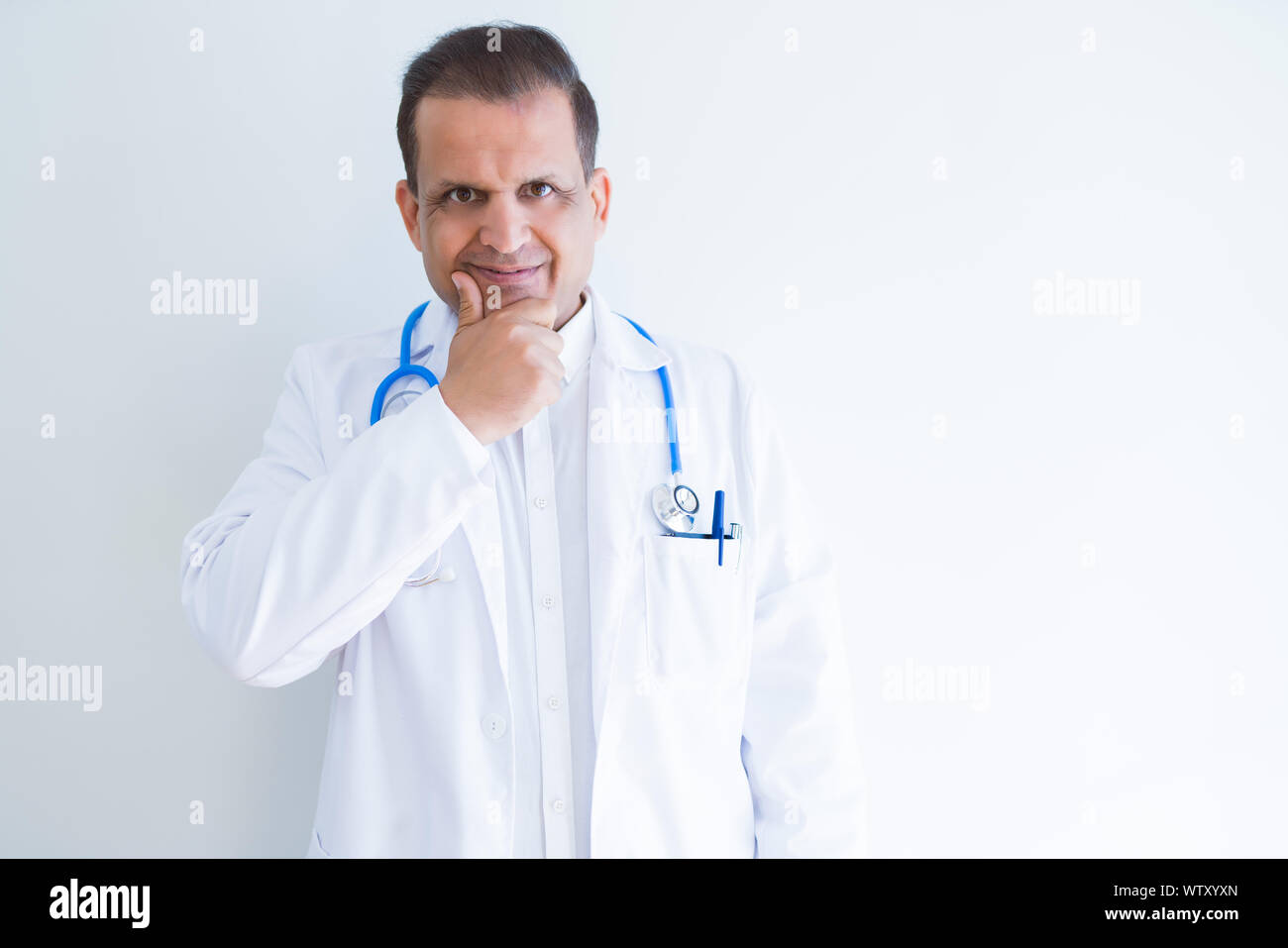 Middle age doctor man wearing stethoscope and medical coat over white ...