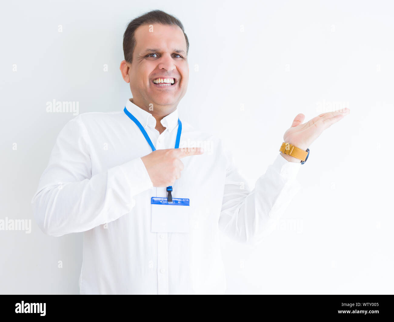 Middle age business man wearing ID card over white background amazed ...