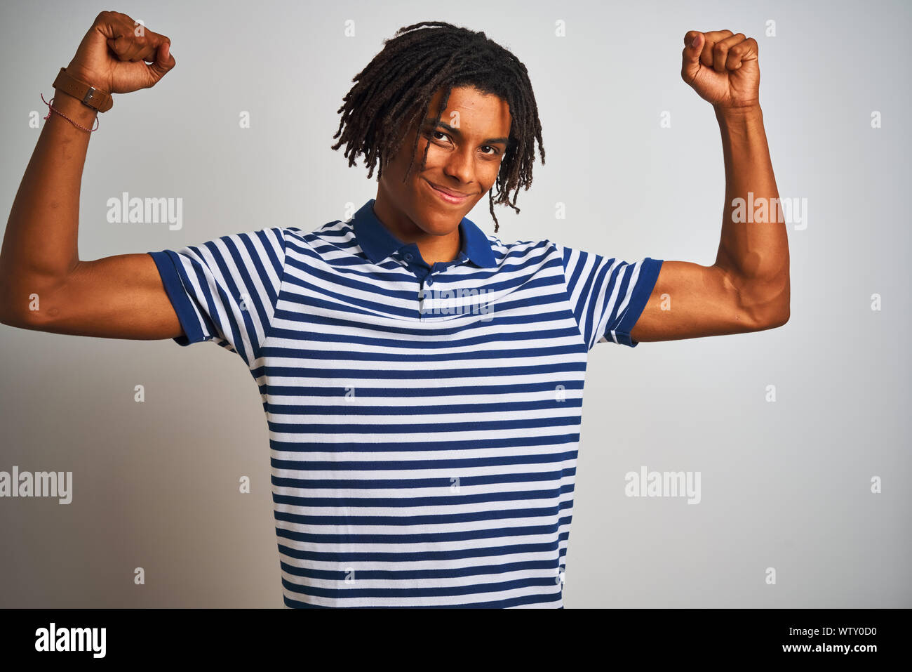 Afro man with dreadlocks wearing striped blue polo standing over ...