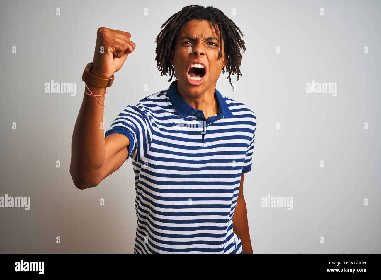 Afro man with dreadlocks wearing striped blue polo standing over ...