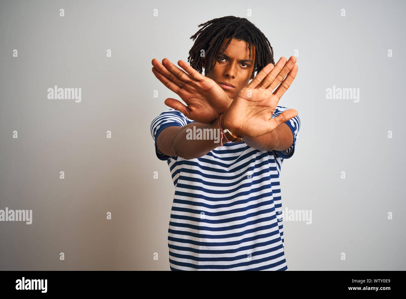 Afro man with dreadlocks wearing striped blue polo standing over ...