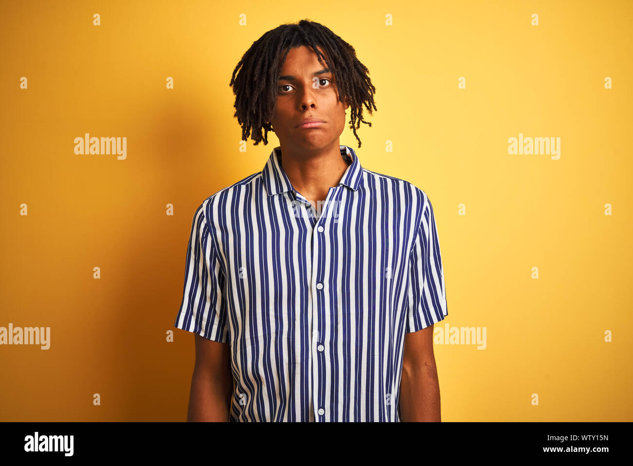 Afro man with dreadlocks wearing casual striped t-shirt over isolated ...