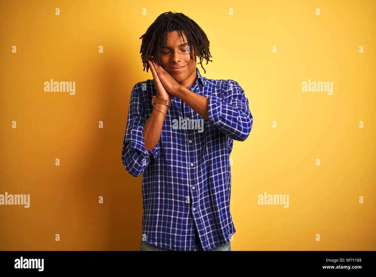 Afro man with dreadlocks wearing casual shirt standing over isolated ...