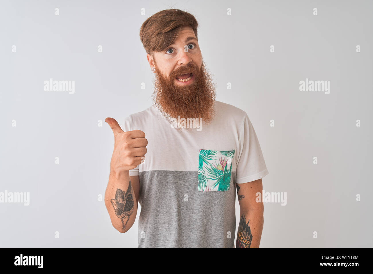 Young redhead irish man wearing t-shirt standing over isolated white ...