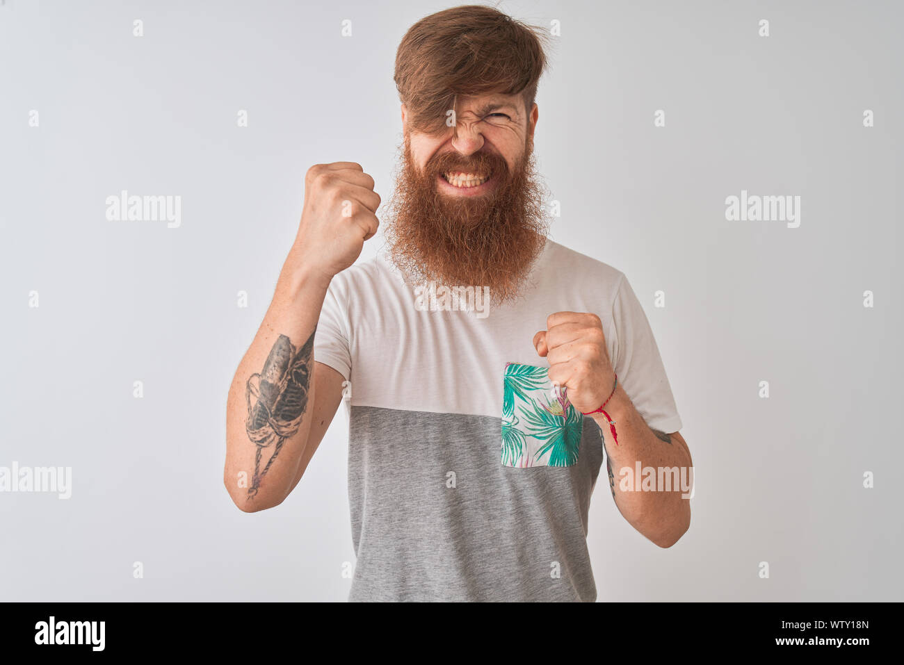 Young redhead irish man wearing t-shirt standing over isolated white ...