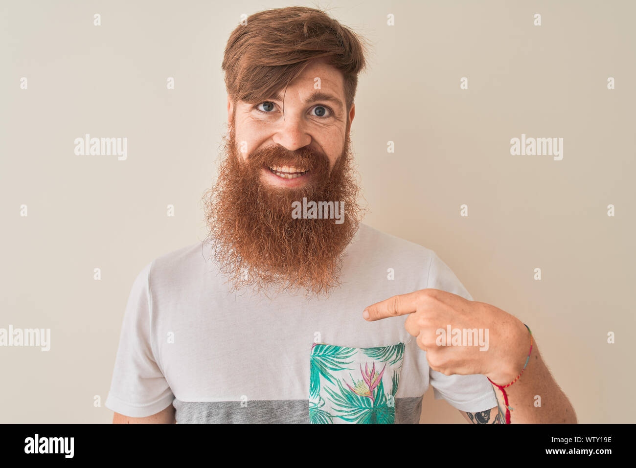 Young redhead irish man wearing t-shirt standing over isolated white ...
