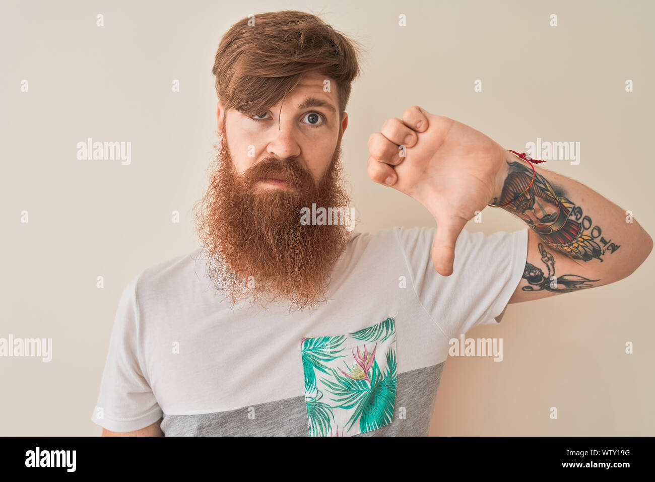 Young redhead irish man wearing t-shirt standing over isolated white ...
