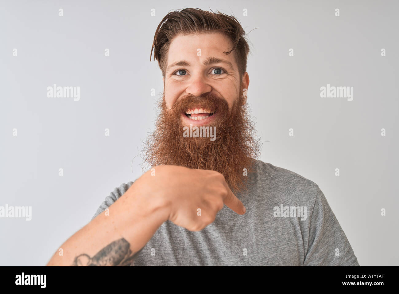 Young redhead irish man wearing t-shirt standing over isolated grey ...