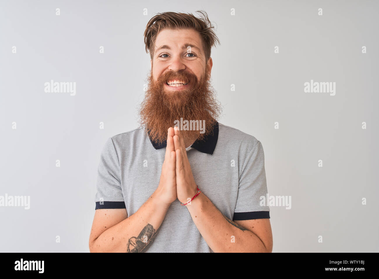 Young redhead irish man wearing grey polo standing over isolated white ...