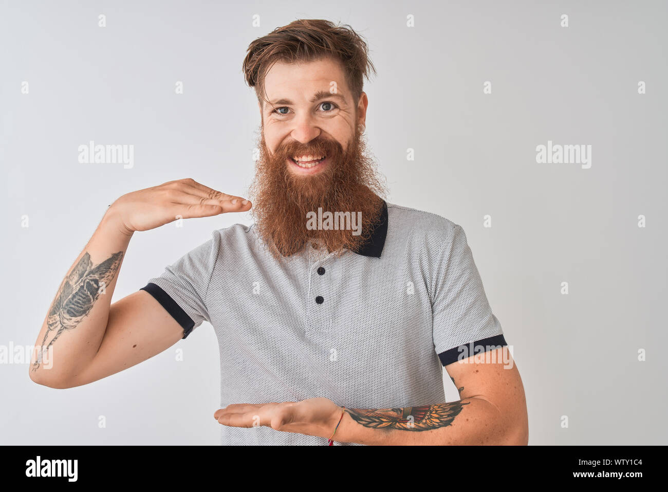 Young redhead irish man wearing grey polo standing over isolated white ...